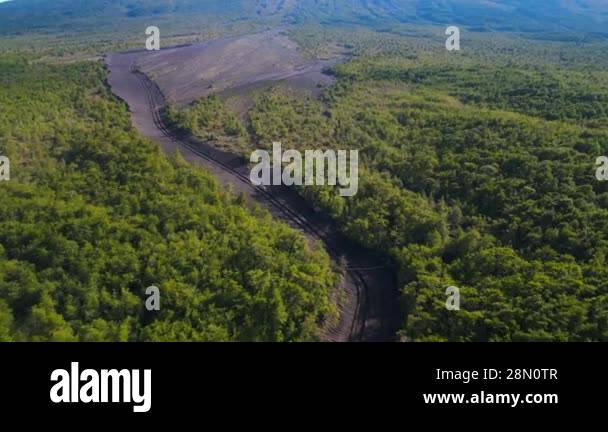 Follow the remnants of a lava trail as it winds through lush greenery ...