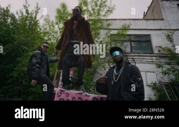 Low angle full shot of Black male rapper in brown fur coat and pants ...