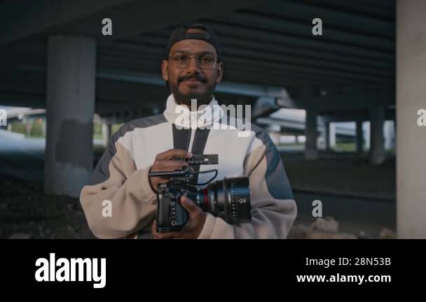 Medium slowmo portrait of Biracial cameraman with beard and moustache ...