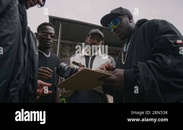 Low angle shot of cool rapper with backup dancers wearing sunglasses ...