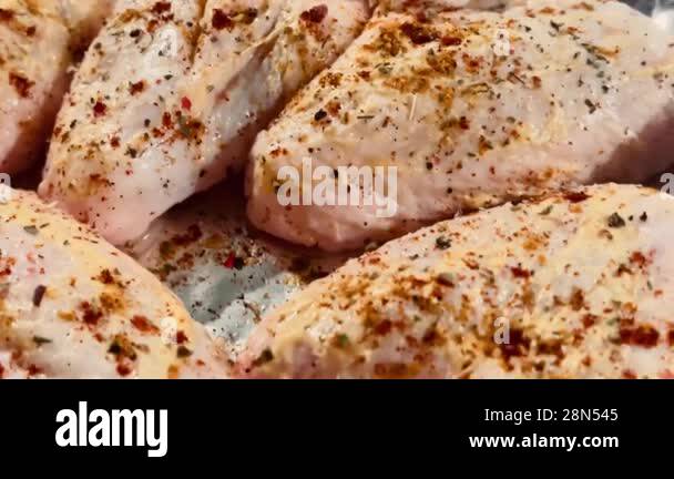 Seasoned raw chicken pieces marinated with herbs and spices, ready for ...