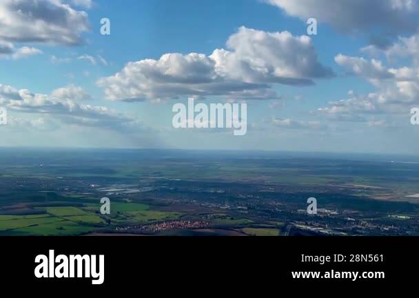 Aerial view of the countryside with vast open fields, scattered clouds ...