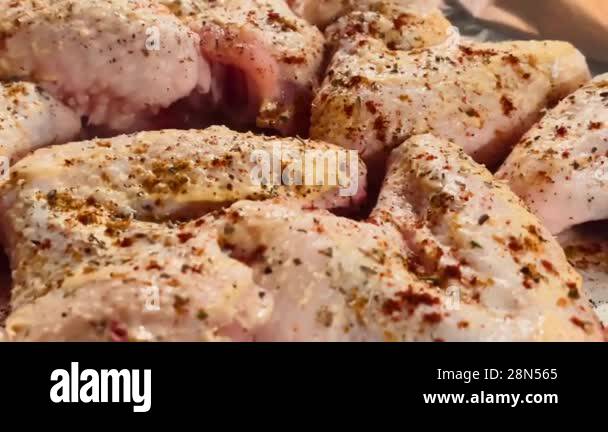 Seasoned raw chicken pieces marinated with herbs and spices, ready for ...