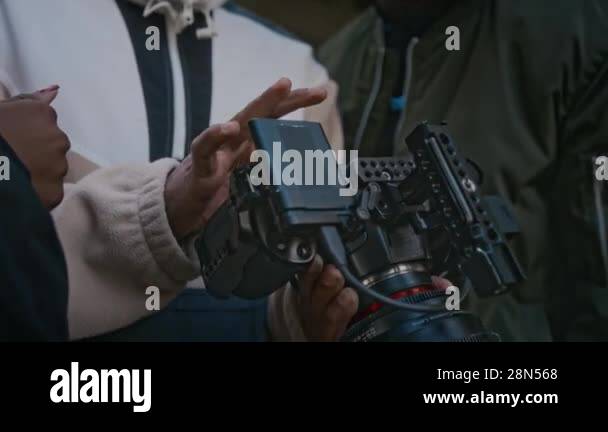 Tilt close-up shot of Biracial male videographer and African American ...
