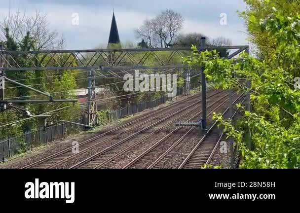 Railway tracks extending into the distance, framed by lush greenery and ...