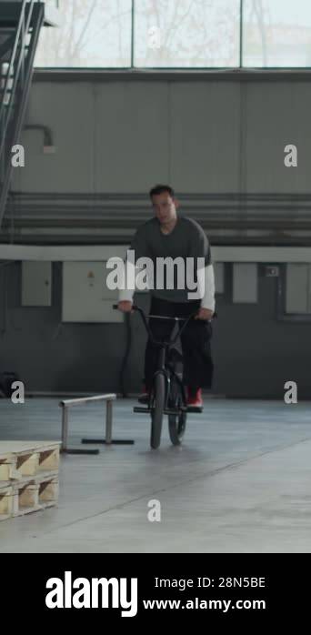Vertical full stab shot of young Caucasian guy stunt riding on BMX ...