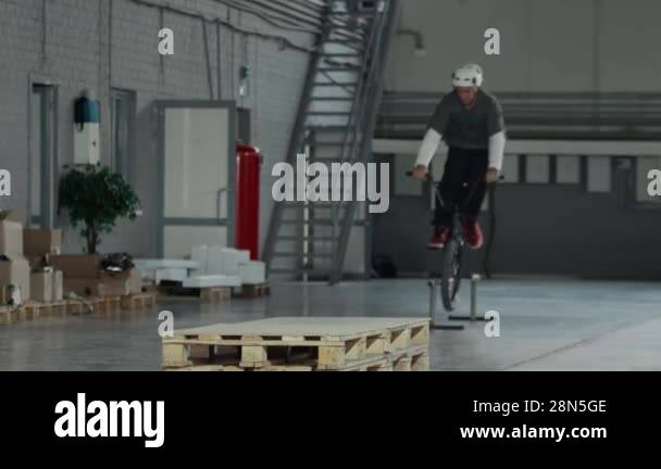 Full slowmo shot of young experienced Caucasian male BMX stunt rider in ...