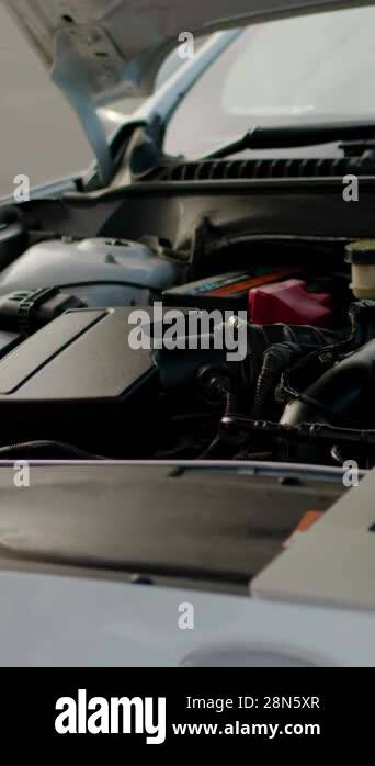 Technician works with tool and repairs car using laptop. Man works on fixing malfunction of ...