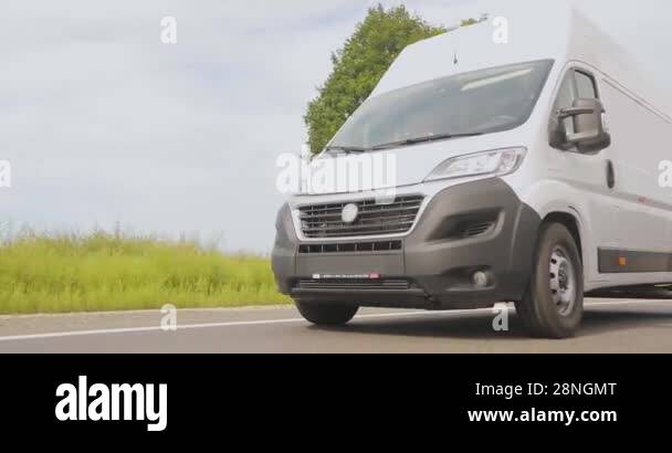 Cargo minibus drives on the highway in sunny weather. White Cargo ...