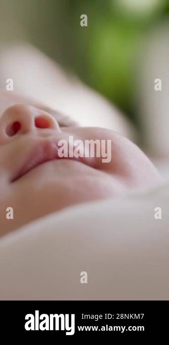 Close-up image of a baby playing and putting his hands in his mouth ...