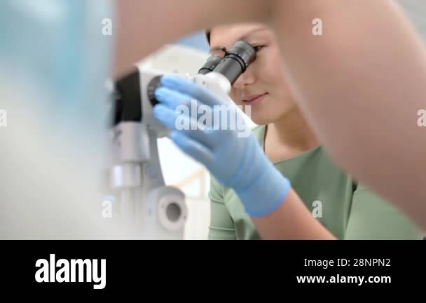 Gynecologist examines a patient using microscope in a gynecological ...