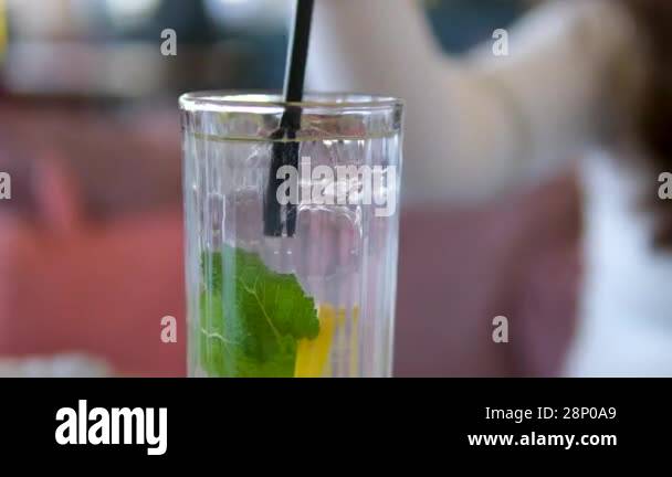 Making fresh summer cocktail. pouring carbonated water in glass with ice cubes. Slow motion ...
