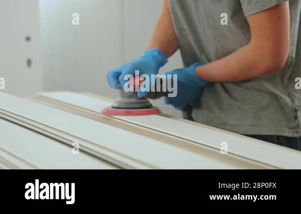 carpenter grinding wood with sandpaper in carpentry or diy workshop ...