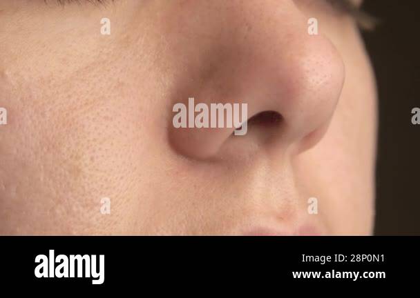 A close-up video of a woman's nose as she moves her nasal muscles ...