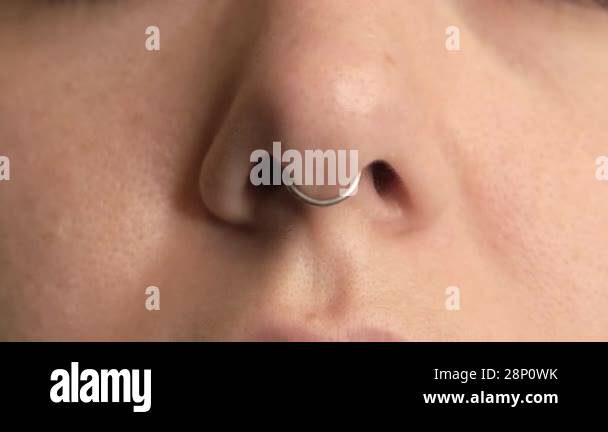 A close-up video of a woman's nose as she moves her nasal muscles ...