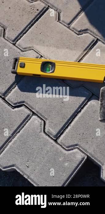 A rubber mallet and a yellow level tool resting on newly placed ...