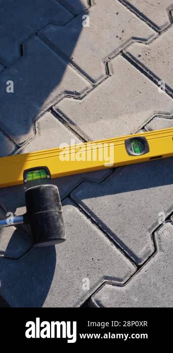 A rubber mallet and a yellow level tool resting on newly placed ...