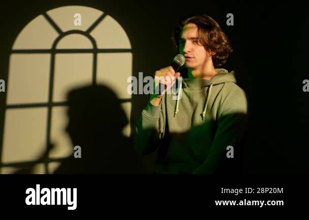 Person with mic on colorful studio background. Portrait of man in green ...