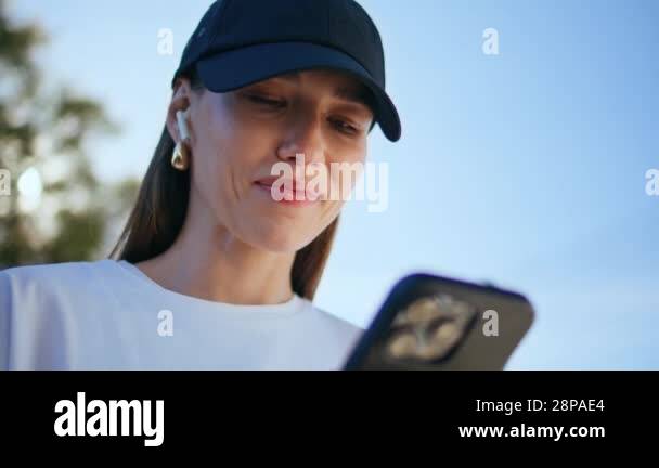 Stylish lady messaging smartphone outdoors closeup. Portrait smiling ...