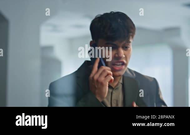 Angry boss arguing mobile phone gesturing expressively at glass office ...