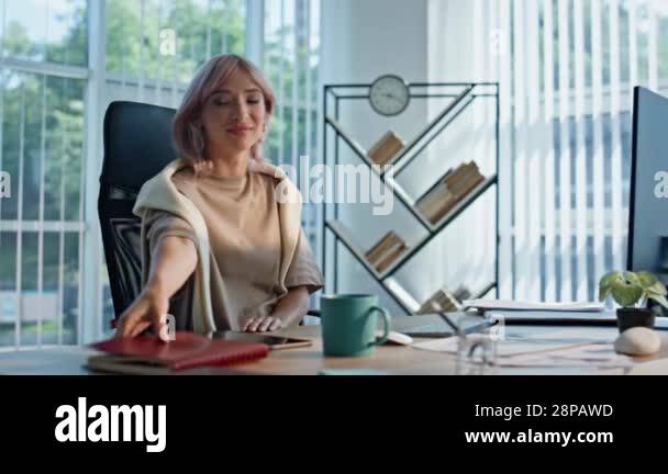 Blonde lady flipping notebook working computer in open space office ...