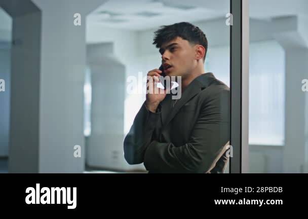 Manager negotiating by cellphone call inside office building closeup ...