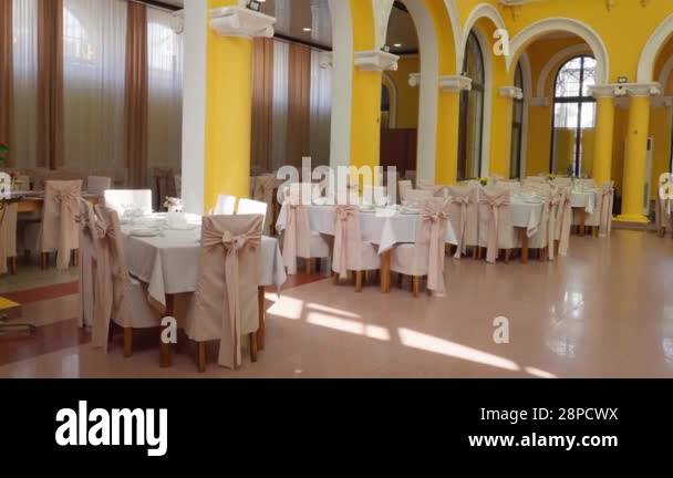 Large ballroom with round tables and beige chairs decorated with ...