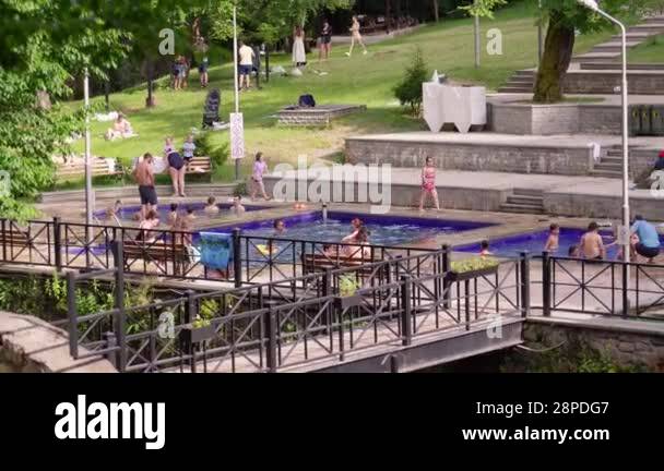People relax and bathe in public open-air thermal pool with water from ...