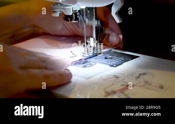 Person using a sewing machine with a garment, for repair work ...