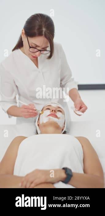Applying anesthesia to a womans facial skin by a beautician in ...