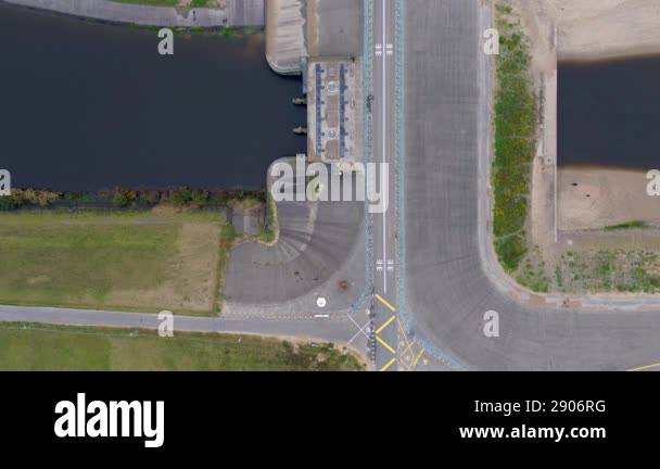 Aerial top-down view of a water canal, concrete structures, roads, and ...