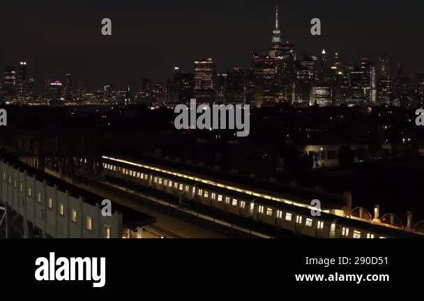 Aerial view of New York City at night. A subway train passes in the ...