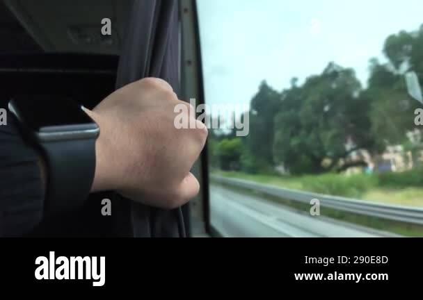 Hand resting on bus window while traveling through scenic landscape in ...