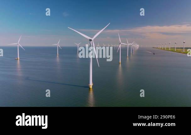 Windmill park in the ocean, drone aerial view of windmill turbines generating green energy ...
