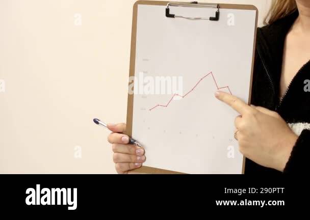 Close up of female hands pointing with a pen a line diagram on paper ...