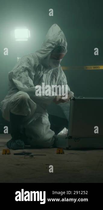 Vertical full lowkey shot of forensic expert wearing protective suit ...
