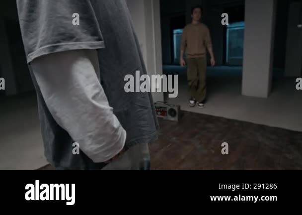 Low angle shot of two Caucasian male zoomers in hip hop clothes talking ...