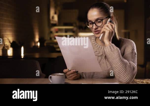 Hispanic woman working in cafe in the evening. Busy lady talking on ...