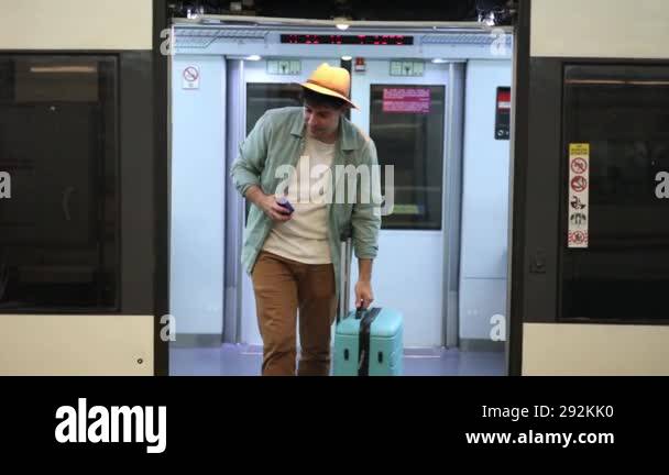 happy traveler stepping off the train with their suitcase in hand ...