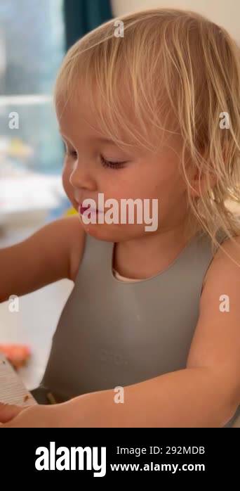 A young child is enthusiastically engaging with their meal at a dining ...