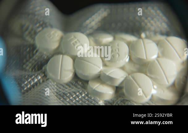 Police investigator in blue gloves studying seized illegal drugs packed ...