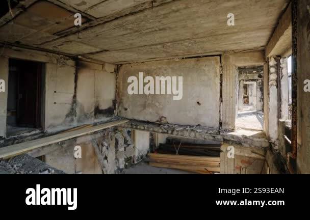Empty, destroyed building interior with debris, exposed beams, damaged ...