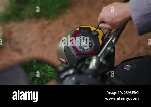 Biker hand inserts the key into the ignition of the motorcycle and ...