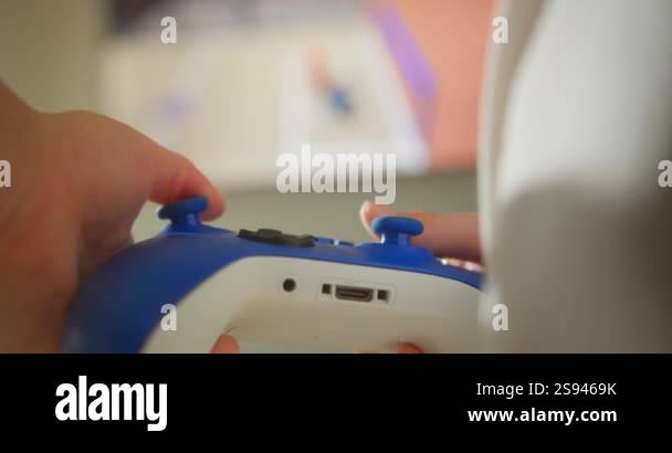 Close-up of hands using a controller to play video games, with a focus ...