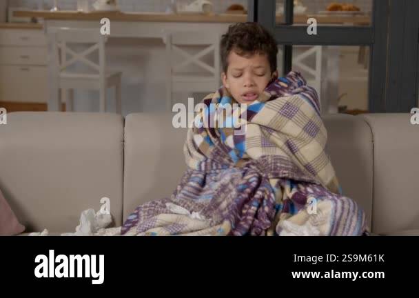 Unwell preadolescent African American boy with high fever struggling ...