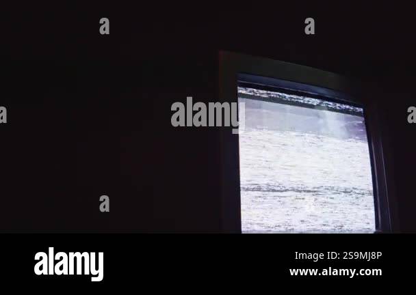 A vintage CRT TV screen displaying static interference with analog ...