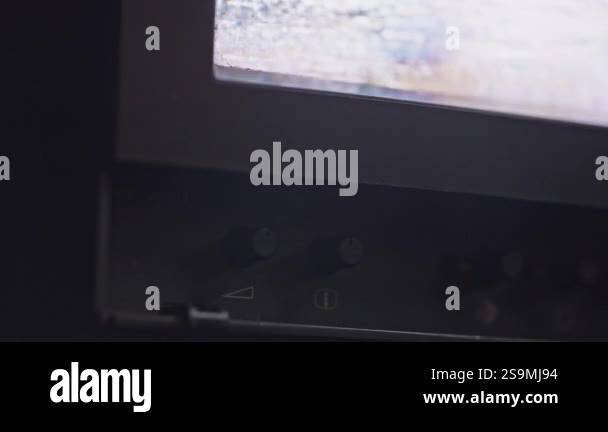 A close-up shot of vintage retro TV buttons, with static noise and ...