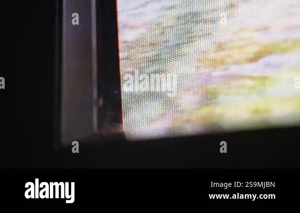 A vintage CRT TV displaying distorted video and glitchy static noise ...