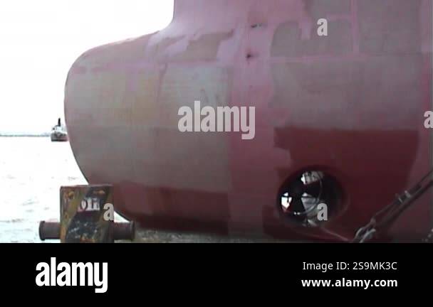 Camcorder footage captures a side view of a large cargo ship ...