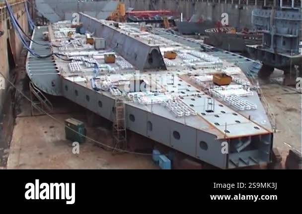 Camcorder footage captures a shipyard under construction, featuring a ...